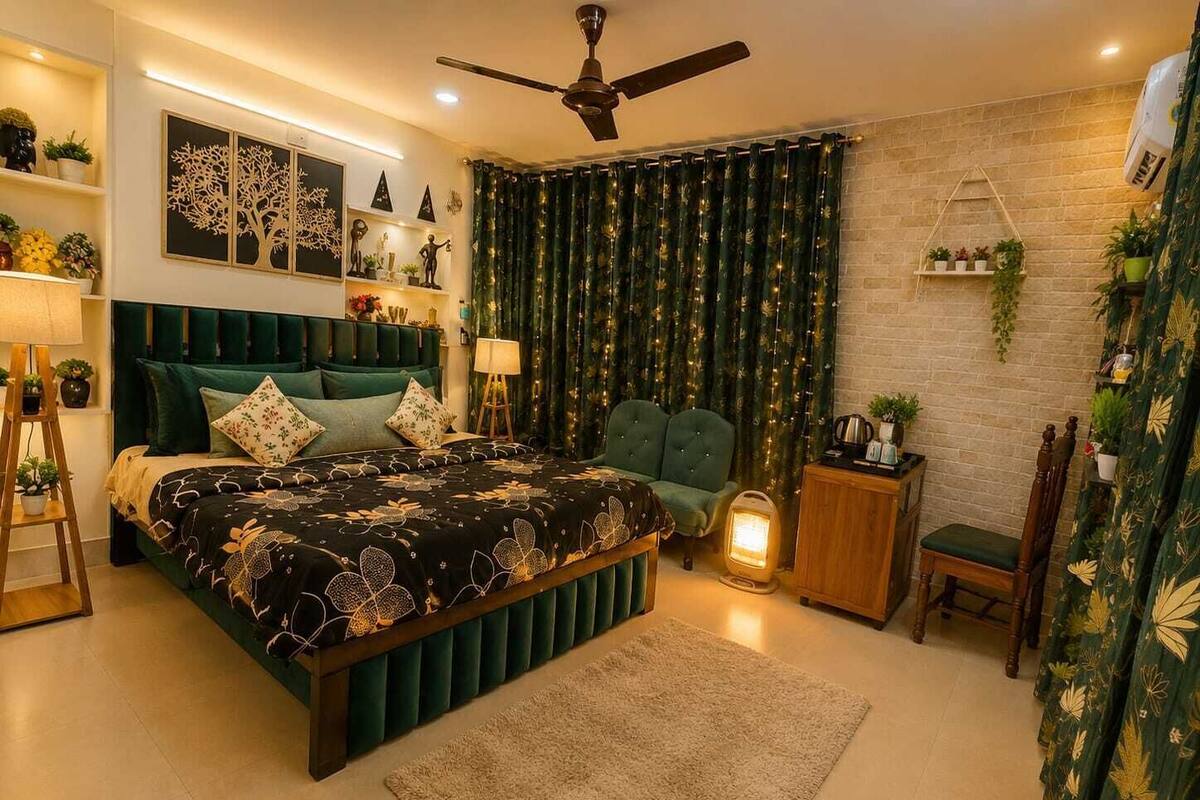 Quarto com cama, mesas de cabeceira, uma cadeira, abajur, ventilador de teto e decoração nas paredes.