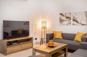 Apartamento básico, várias camas | Área de estar | TV