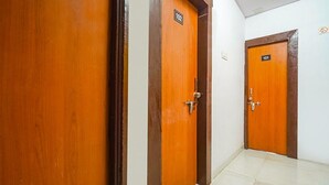 Um corredor com três portas de madeira, cada uma marcada com um número.