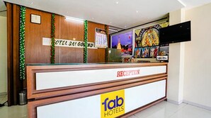Uma receção de hotel com uma placa a indicar 'Hotel Sai Gond' e uma etiqueta a dizer 'Recepção'.