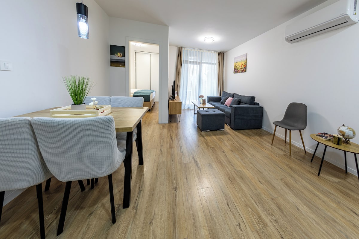 Apartamento superior, 1 quarto | Área de estar | TV de tela plana 55 polegadas com canais a cabo