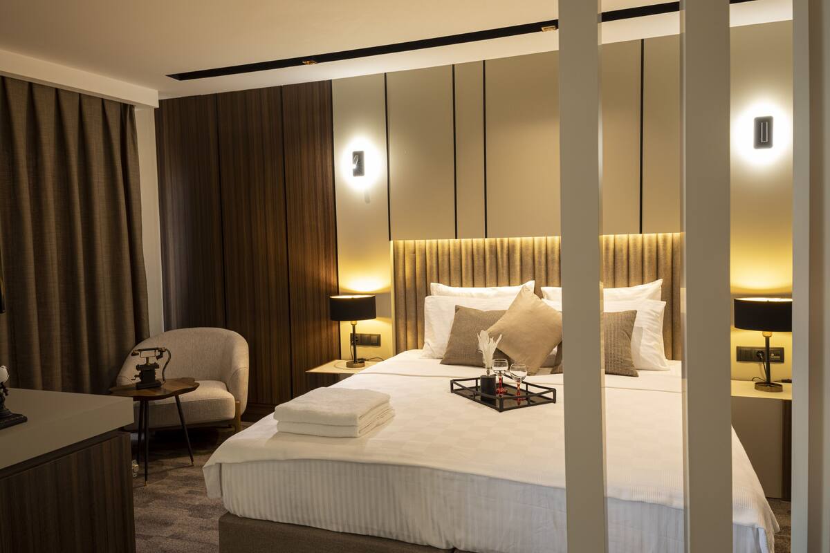 Quarto de hotel moderno com uma cama grande, uma escrivaninha e uma cadeira.