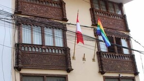 Um edifício com uma placa indicando o hotel 'La Joya Imperial', apresentando uma varanda com uma bandeira e uma placa de publicidade do hotel.