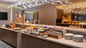 Disposição moderna de buffet com diversos alimentos e iluminação contemporânea.
