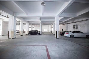 Garagem de estacionamento com vários andares e diversos carros estacionados.