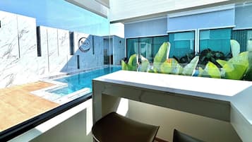 Quarto de hotel moderno com parede de mármore, piscina e vista para o céu.