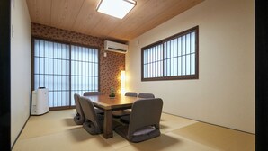 Um quarto japonês tradicional com tatames, uma mesa baixa e biombos shoji.