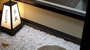 Um quarto tradicional japonês com tatames, um painel shoji e um candeeiro com caracteres japoneses.