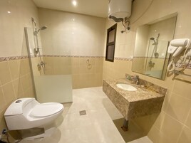 Casa de banho com sanita, lavatório, chuveiro e secador de cabelo.