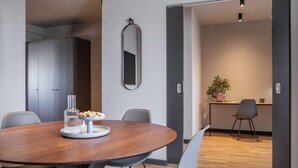 Uma área de jantar moderna com uma mesa redonda, cadeiras e um pequeno tabuleiro com comida.