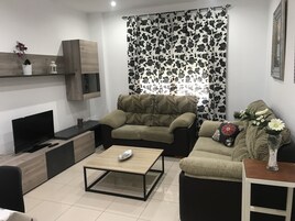 Apartamento empresarial | Área de estar | TV de tela plana