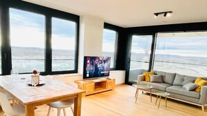 Uma sala de estar moderna com uma mesa de jantar, sofá e TV.