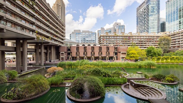 Um hotel moderno urbano com vários andares, um jardim no terraço e um pátio central com fontes.