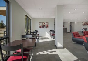 Interior moderno com área de refeições, assentos e obras de arte nas paredes.