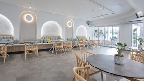 Um interior moderno com amplo espaço aberto, áreas de estar e uma mesa de jantar com cadeiras.