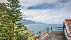 Uma escadaria costeira com vista para o mar e montanhas.