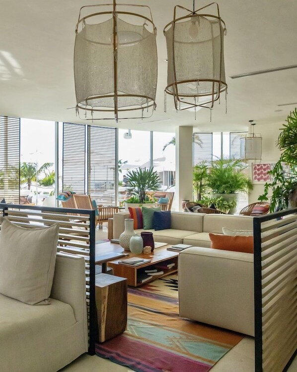 Sala de estar moderna com sofá, mesa de centro e luminárias pendentes.