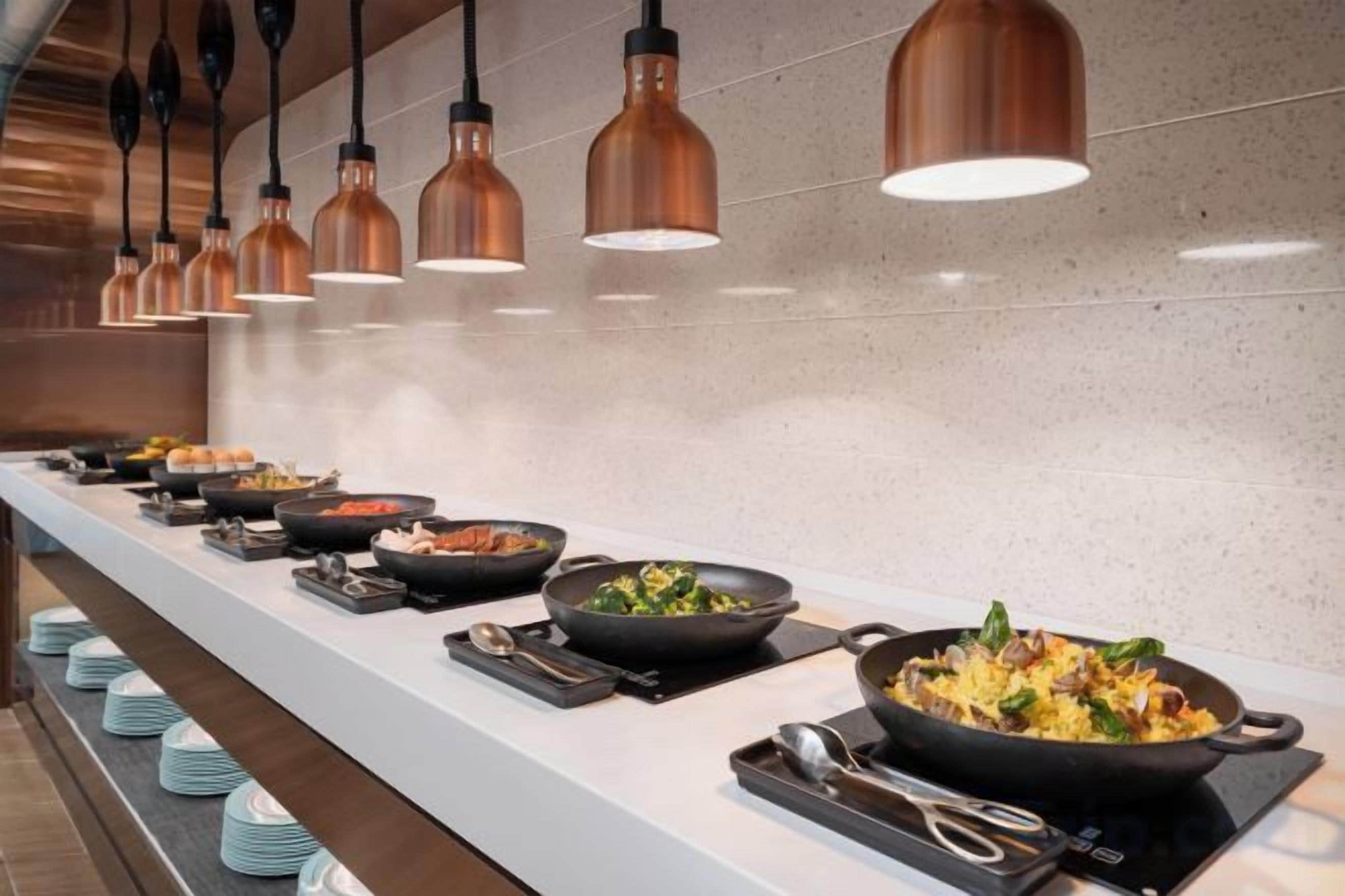 Disposição de buffet com vários pratos e utensílios.