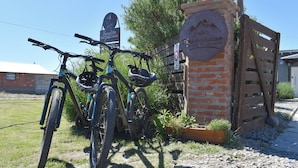 Uma bicicleta de montanha estacionada ao lado de um letreiro com 'Bendita Patagonia' e 'Mara de Glaciares'.