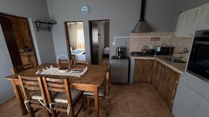Uma cozinha compacta com área de jantar, mobiliário de madeira e eletrodomésticos básicos.