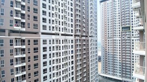 Edifício residencial alto com várias varandas e fachada uniforme.