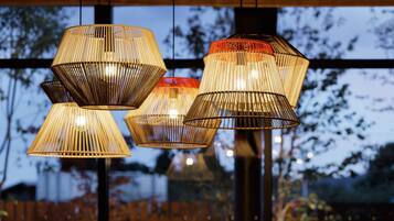 Uma série de luminárias pendentes com design trançado, suspensas no teto.