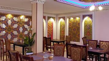 Restaurante com design de teto ornamentado, paredes padronizadas e mobiliário de madeira tradicional.