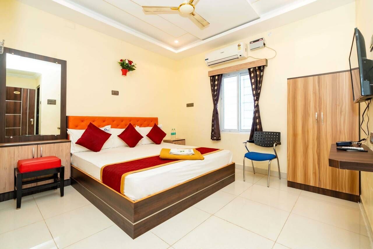 Quarto de hotel com cama, escrivaninha, cadeira, guarda-roupa e ar condicionado.