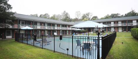 Hotel com área de piscina cercada, área de estar externa e alpendre coberto.