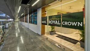 Corredor moderno de hotel com uma placa indicando 'ROYAL CROWN HOTEL'.