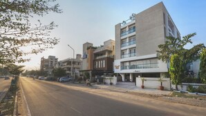 Um hotel moderno com fachada plana, várias varandas e uma placa com a inscrição "Polo Stay".