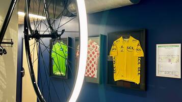 Uma bicicleta com uma roda dianteira, uma camisa emoldurada e um plano de evacuação emoldurado na parede.