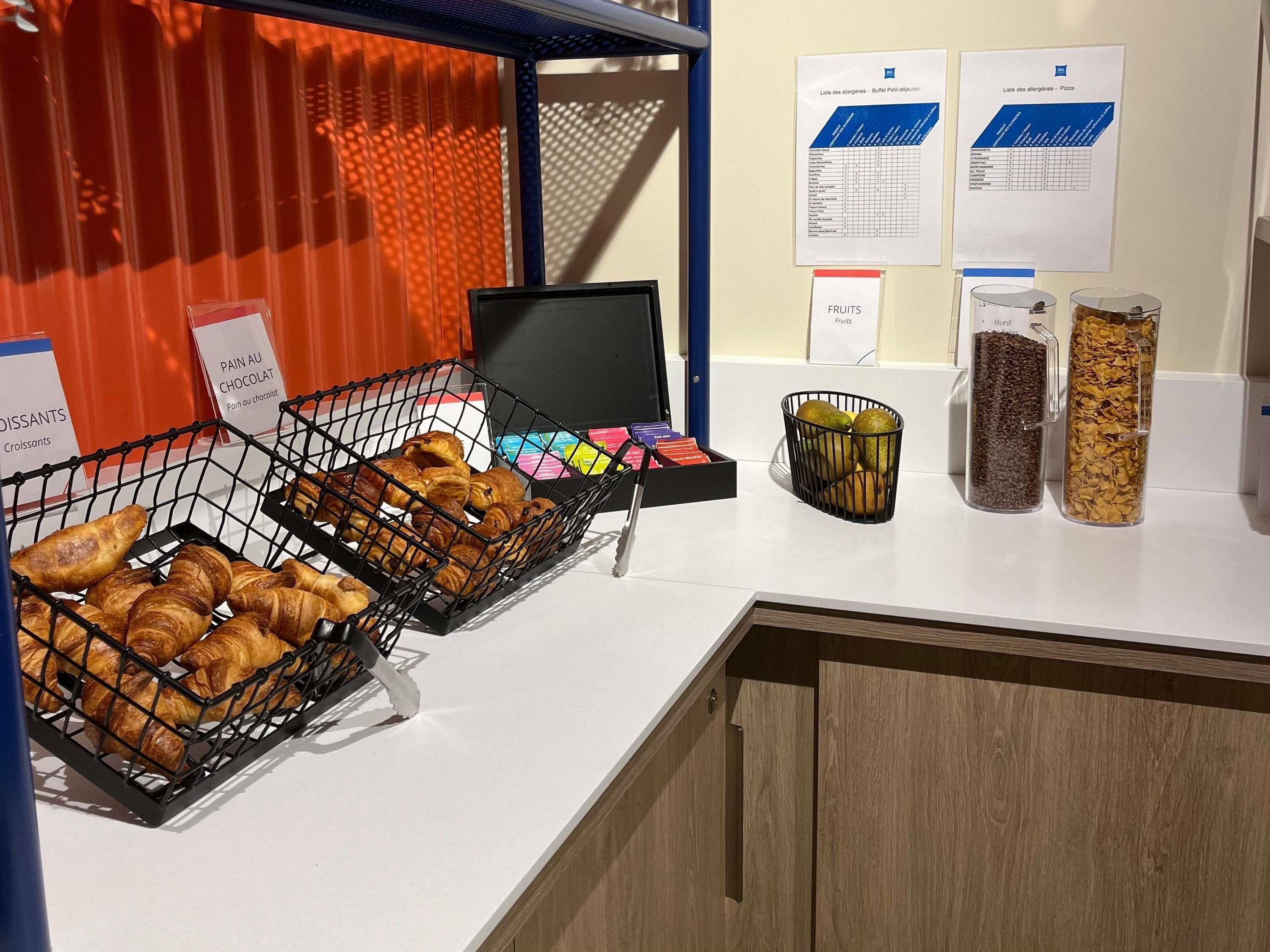 Vitrine de pastelaria com croissants e uma variedade de frutas.