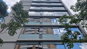 Um edifício moderno de vários andares com grandes janelas e fachada de vidro.