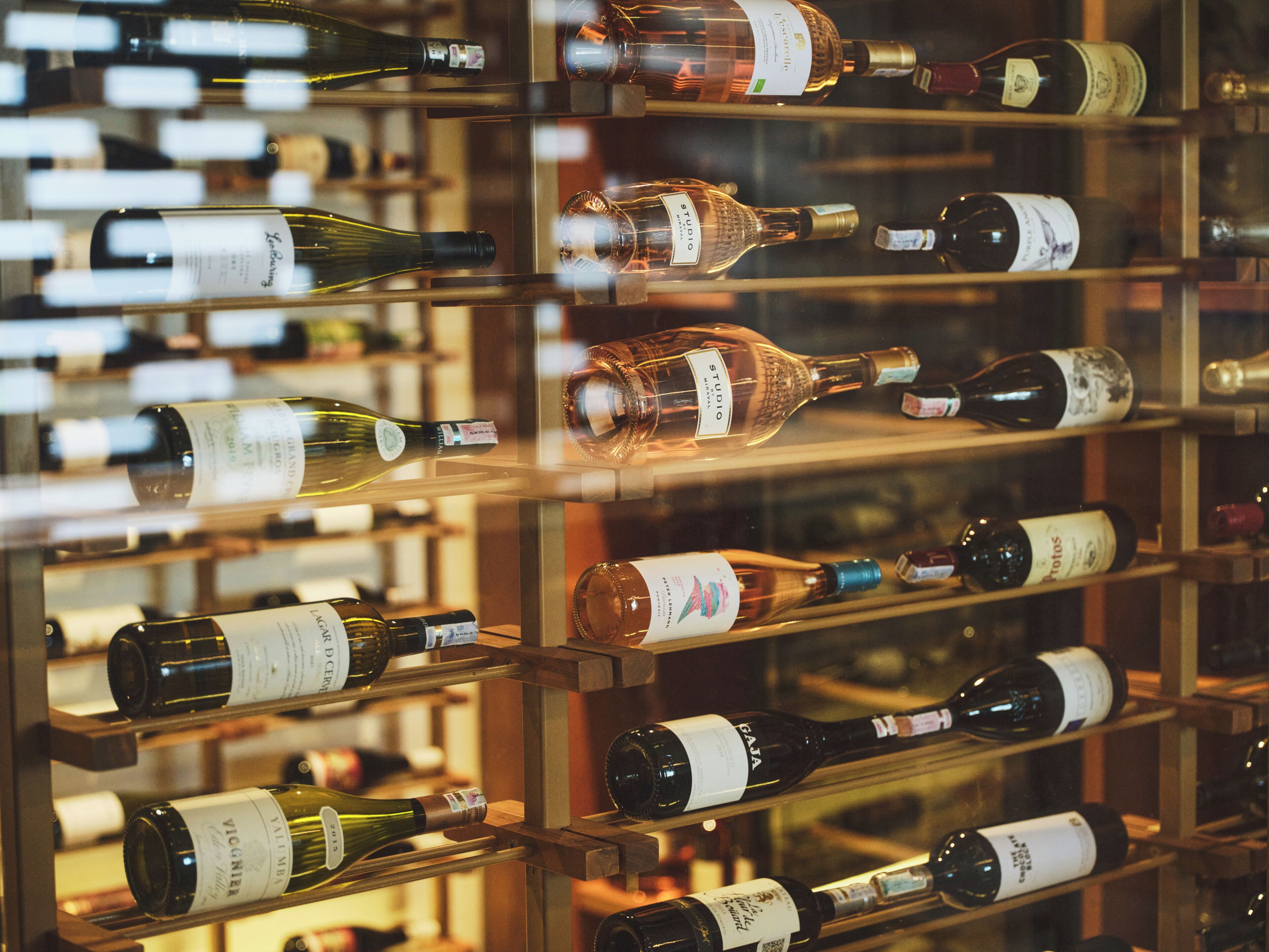 Uma adega com diversas garrafas de vinho nas prateleiras.
