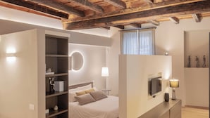 Quarto moderno com cama, estantes embutidas, televisão e espaço para escritório.