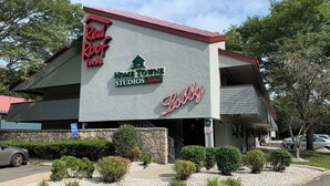 Um edifício com placas indicando 'Red Roof Inn' e 'Home Town Studios by Red Roof'.