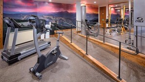 Uma academia com esteiras, elípticos e equipamentos de musculação.