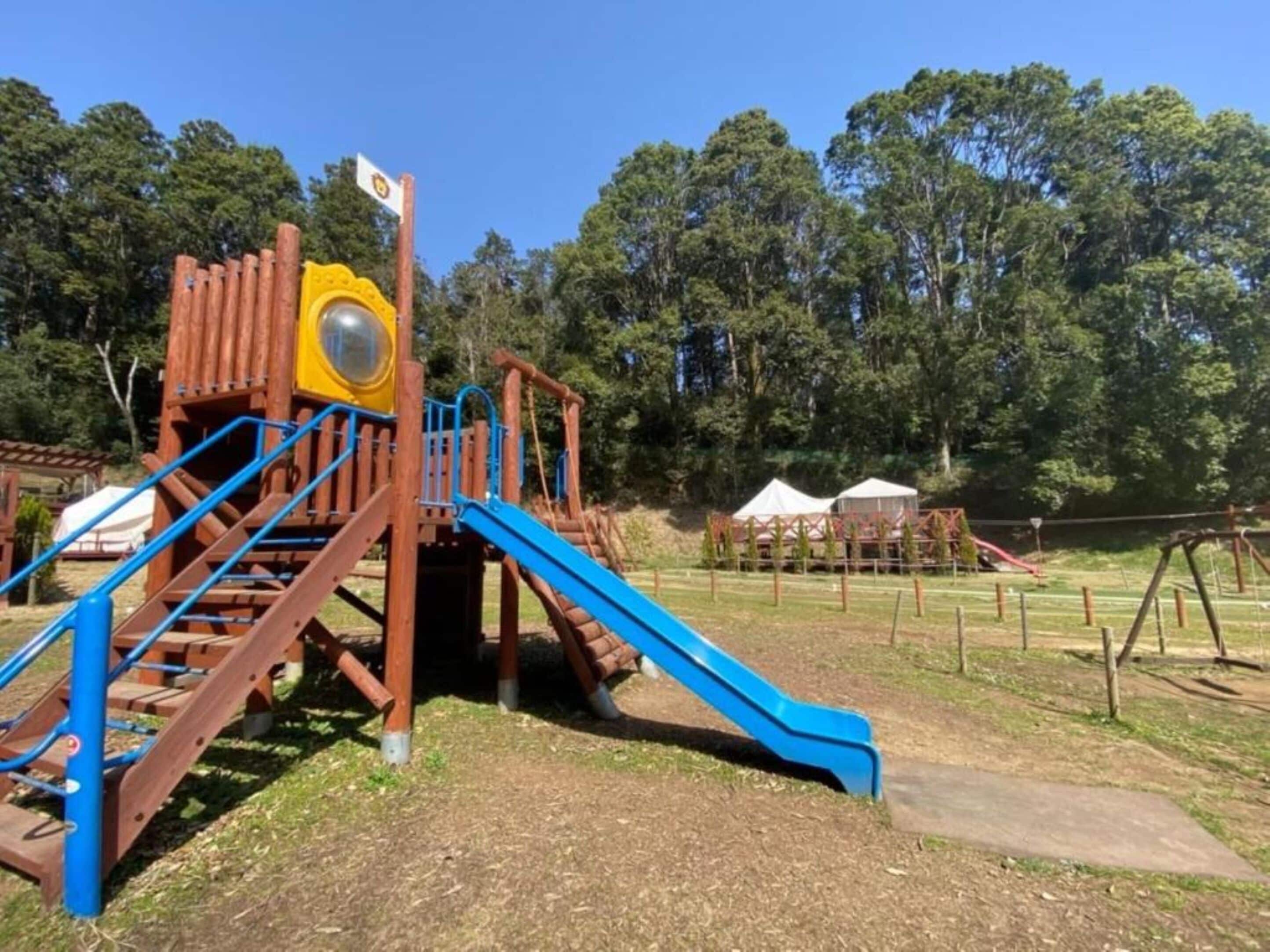 Um parquinho infantil com escorrega e estruturas de escalada.