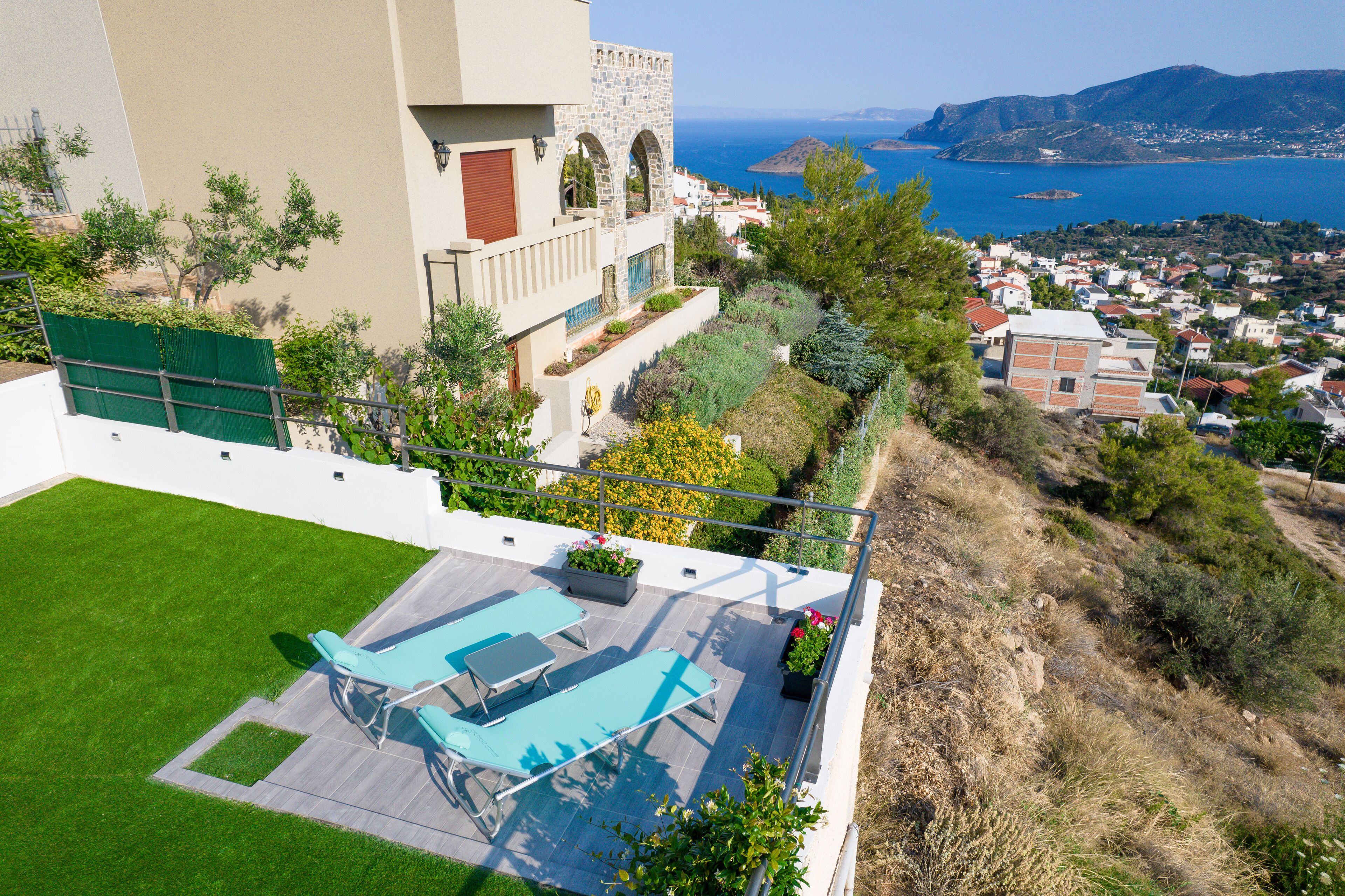Terraço no terraço com mesa de bilhar e espreguiçadeiras, com vista para uma cidade costeira e o mar.