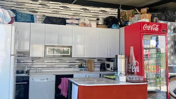 Um frigorífico no espaço comum, um micro-ondas, um forno