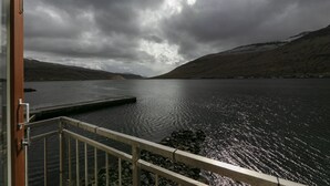 Vista de um lago com um cais e um corrimão em primeiro plano.