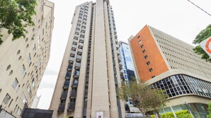 Um edifício alto e moderno com um núcleo central e várias varandas.