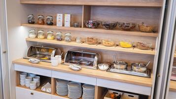 Mesa de buffet com diversos alimentos e utensílios.