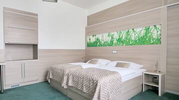Quarto moderno com cama, mesa de cabeceira, prateleira embutida e uma obra de arte na parede.
