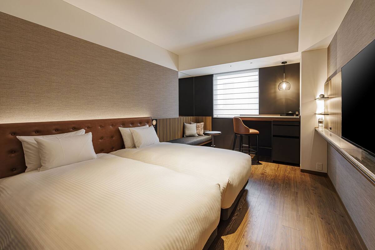 Quarto de hotel com uma cama grande, pequena cozinha e área de estar com vista para a cidade.
