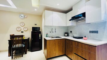 Cozinha moderna com micro-ondas, pia e armários de madeira.