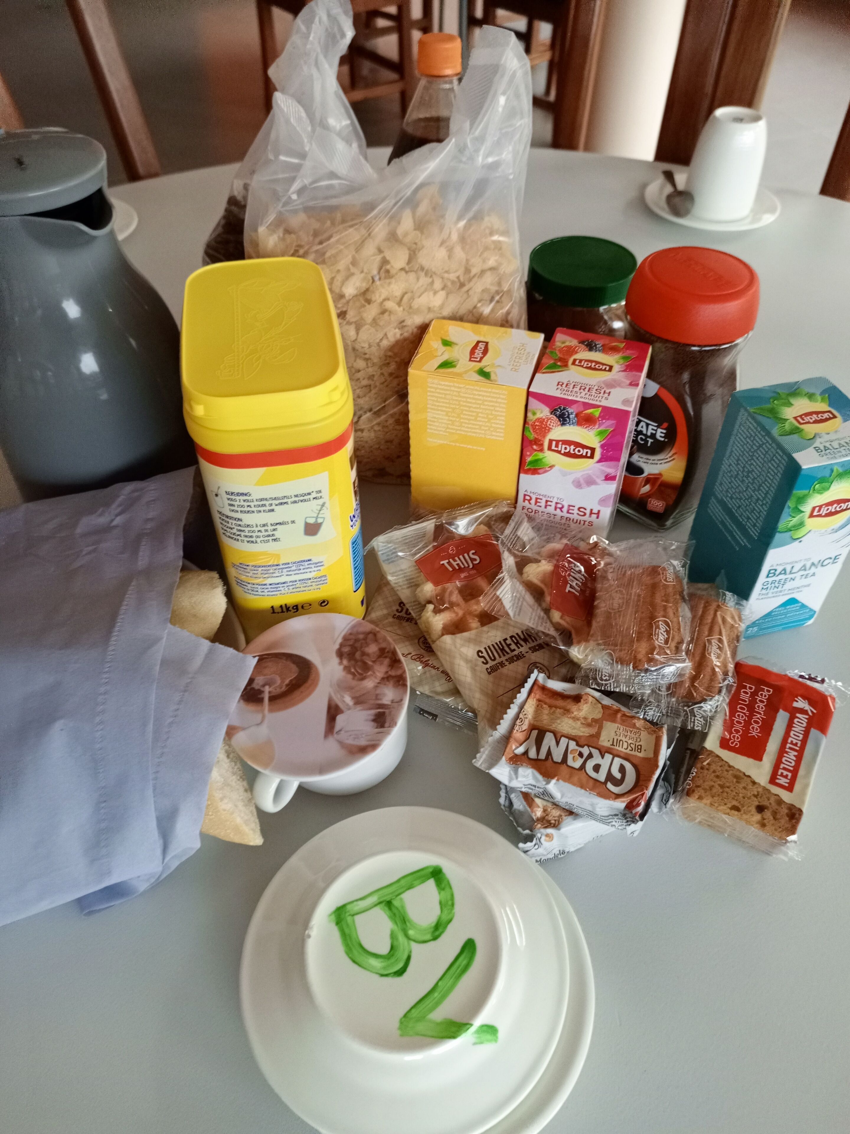 Uma mesa com diversos alimentos e uma xícara com a inscrição 'BL'.