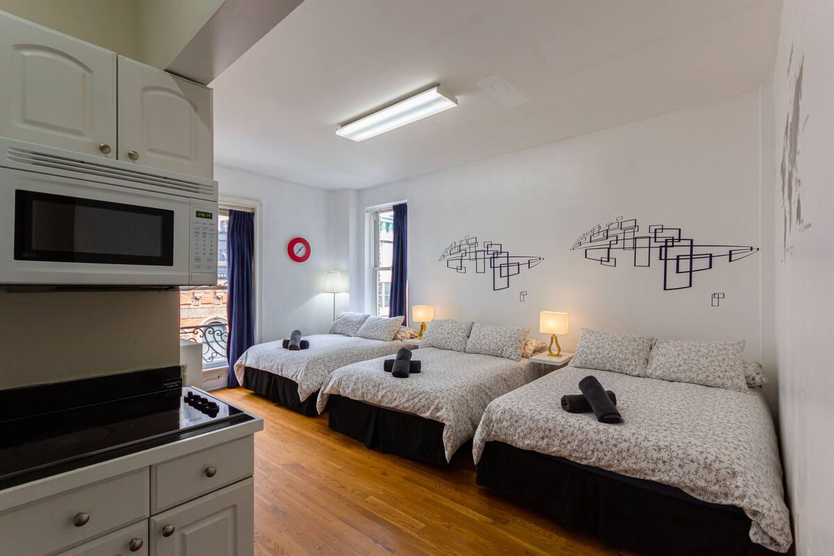 Quarto de hotel com duas camas, micro-ondas e vista para a cidade.