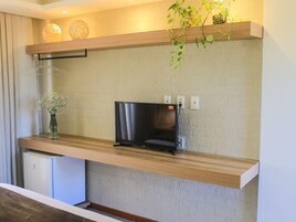 Uma cozinha moderna com micro-ondas embutido, um refrigerador pequeno e bancada de madeira.